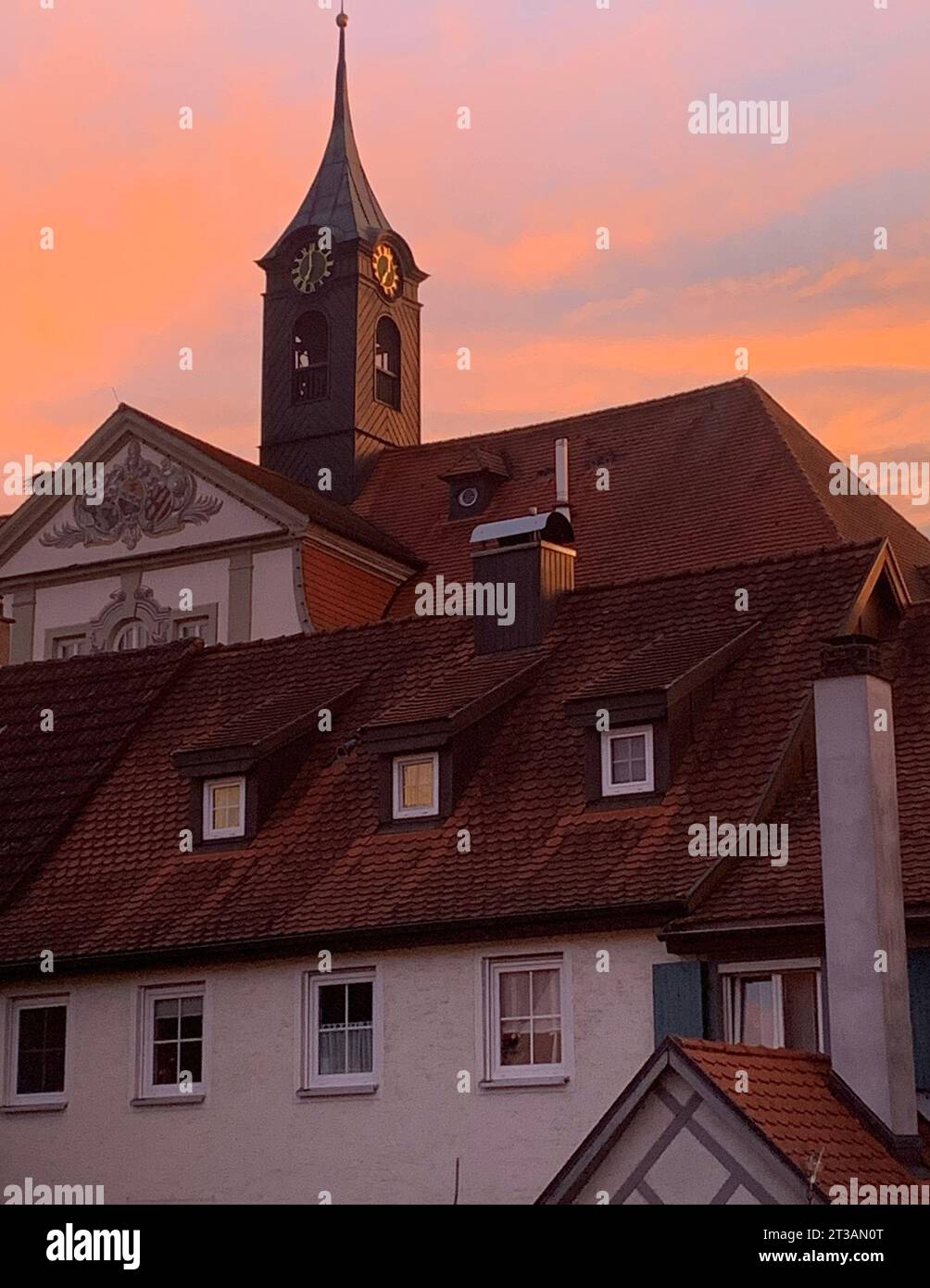 An expansive white building with a grand clock tower rising above it ...
