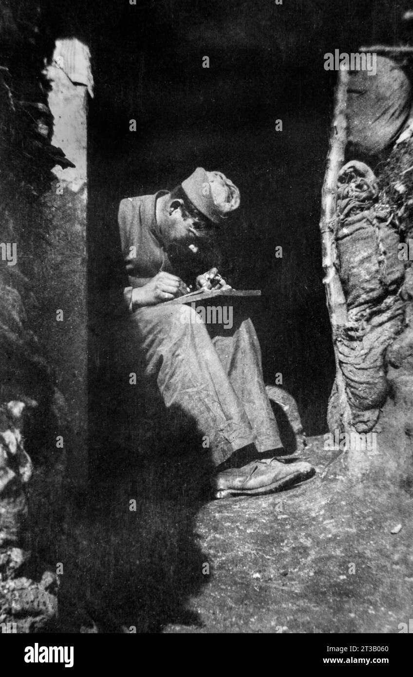 A soldier writing a letter to his family in a trench during the first ...