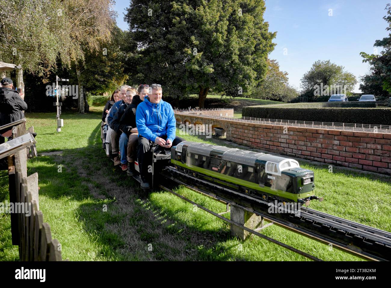 Miniature railway with people riding the narrow gauge train at ...