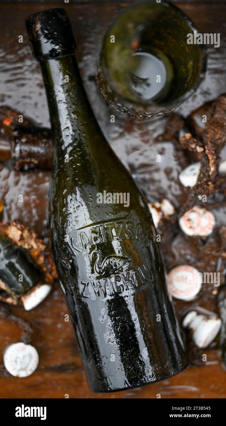 24 October 2023, Saxony, Zwickau: A historic beer bottle lies between ...