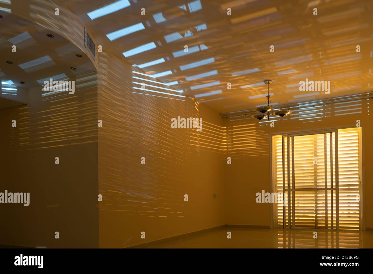 Light filters through the window blinds, casting captivating shadows ...