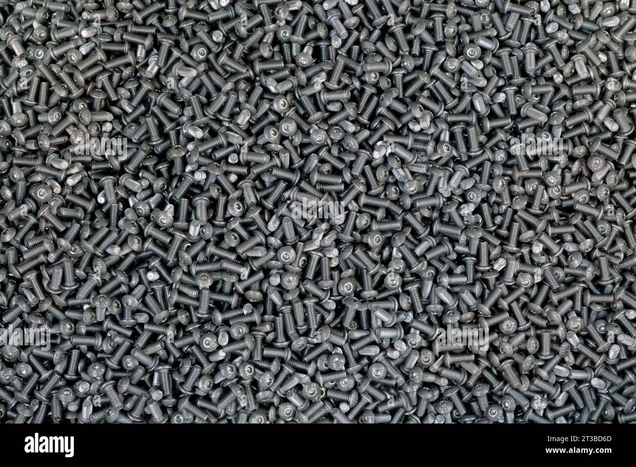 Very large group of black steel screw bolts, abstract industrial ...