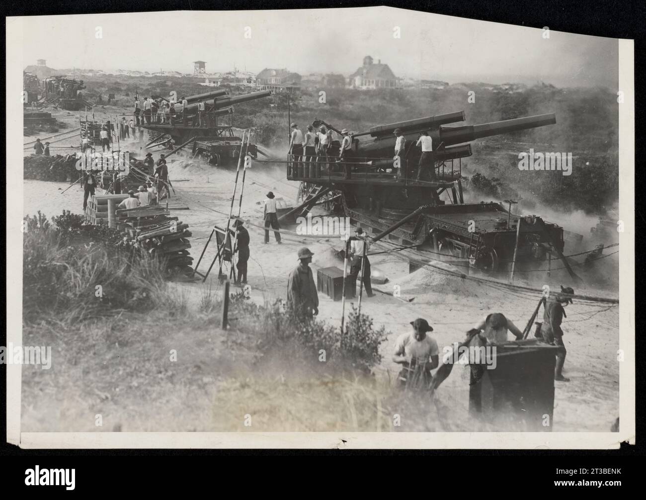 Gun crews firing eight-inch railway mounted guns are shown in action ...