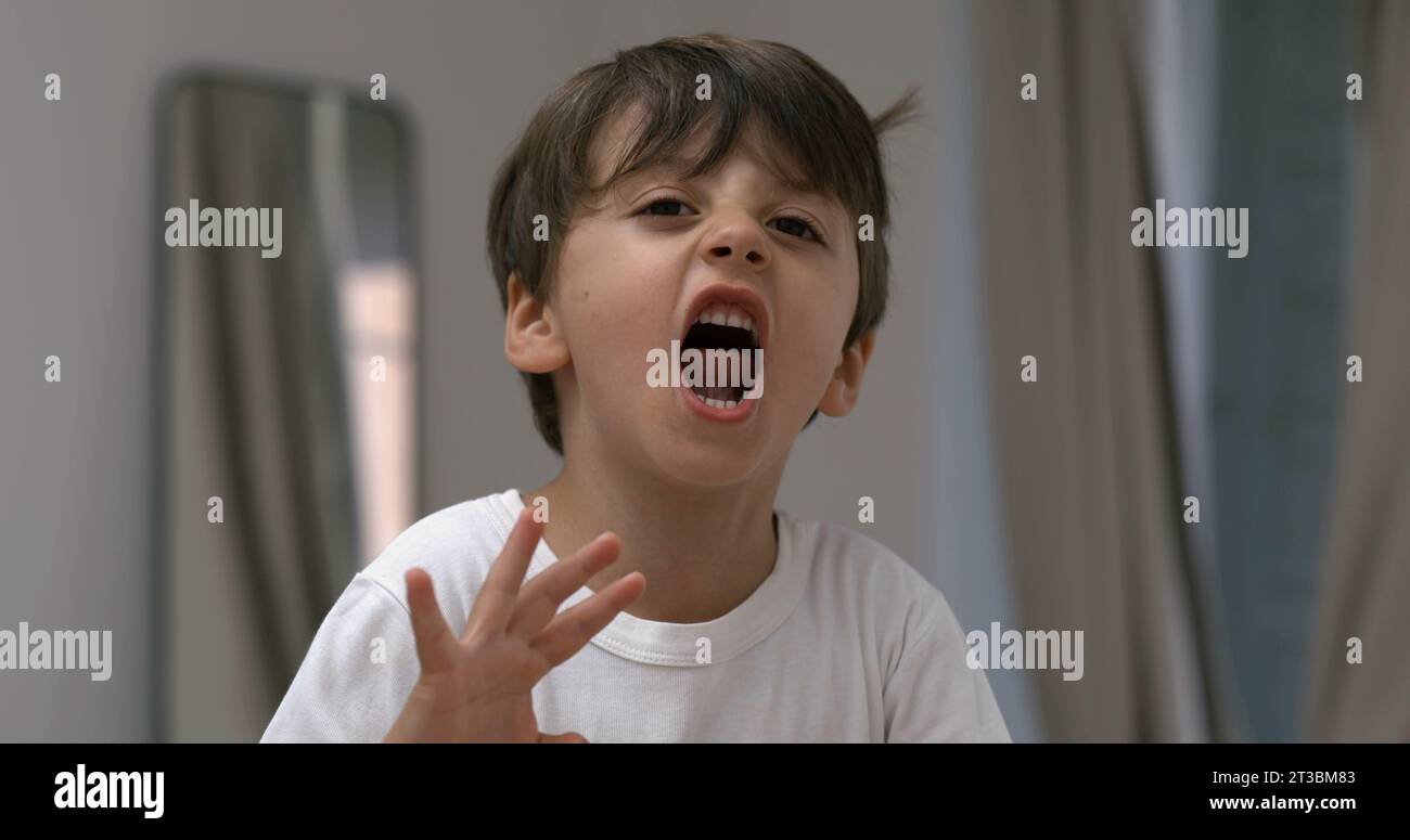 Angry child yelling and screaming at camera in super slow-motion. Upset ...
