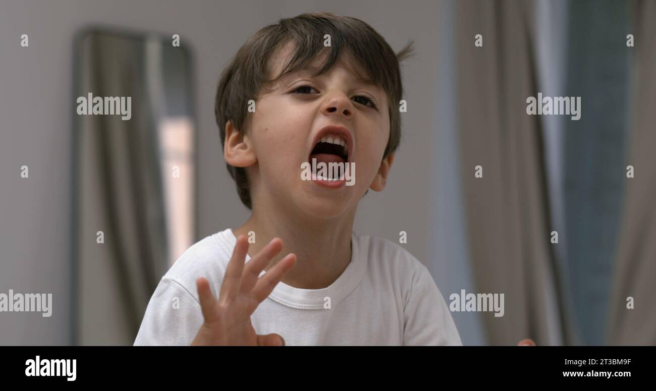 Angry child yelling and screaming at camera in super slow-motion. Upset ...