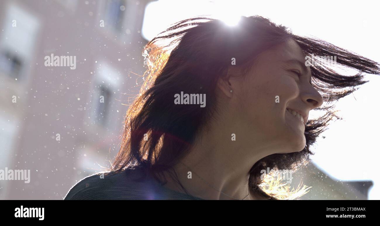 Carefree woman shaking hair in super slow-motion outside in the ...