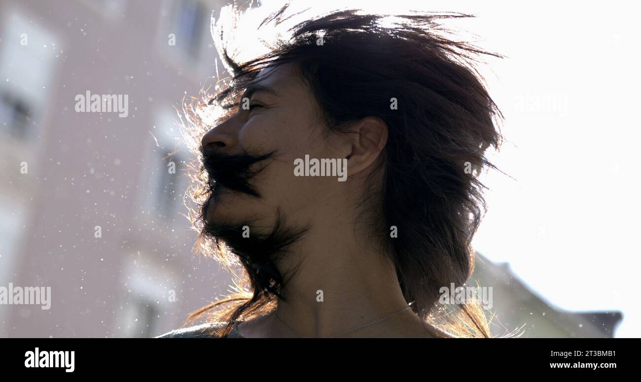 Carefree woman shaking hair in super slow-motion outside in the ...