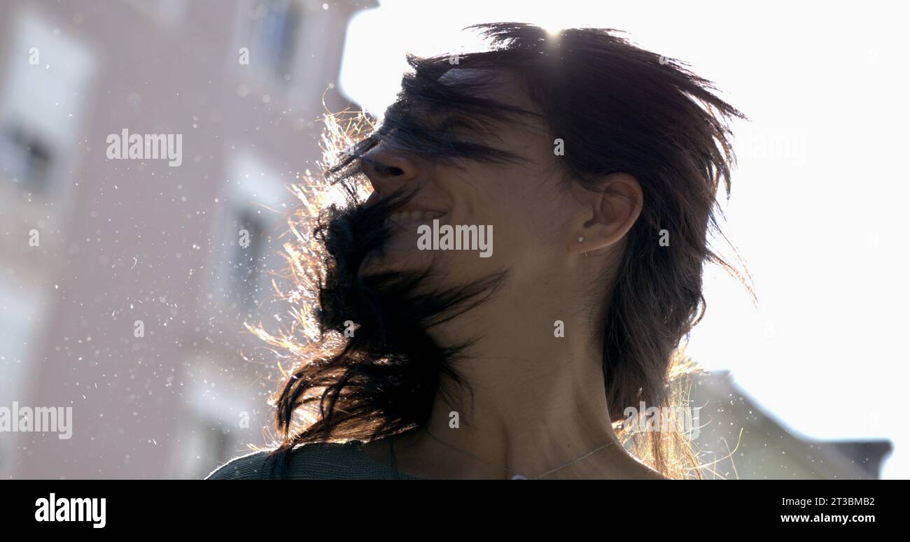 Carefree woman shaking hair in super slow-motion outside in the ...