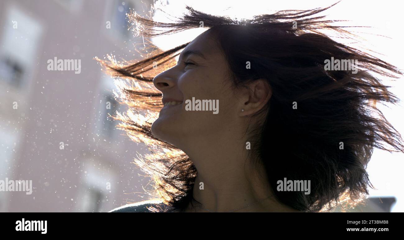 Carefree woman shaking hair in super slow-motion outside in the ...