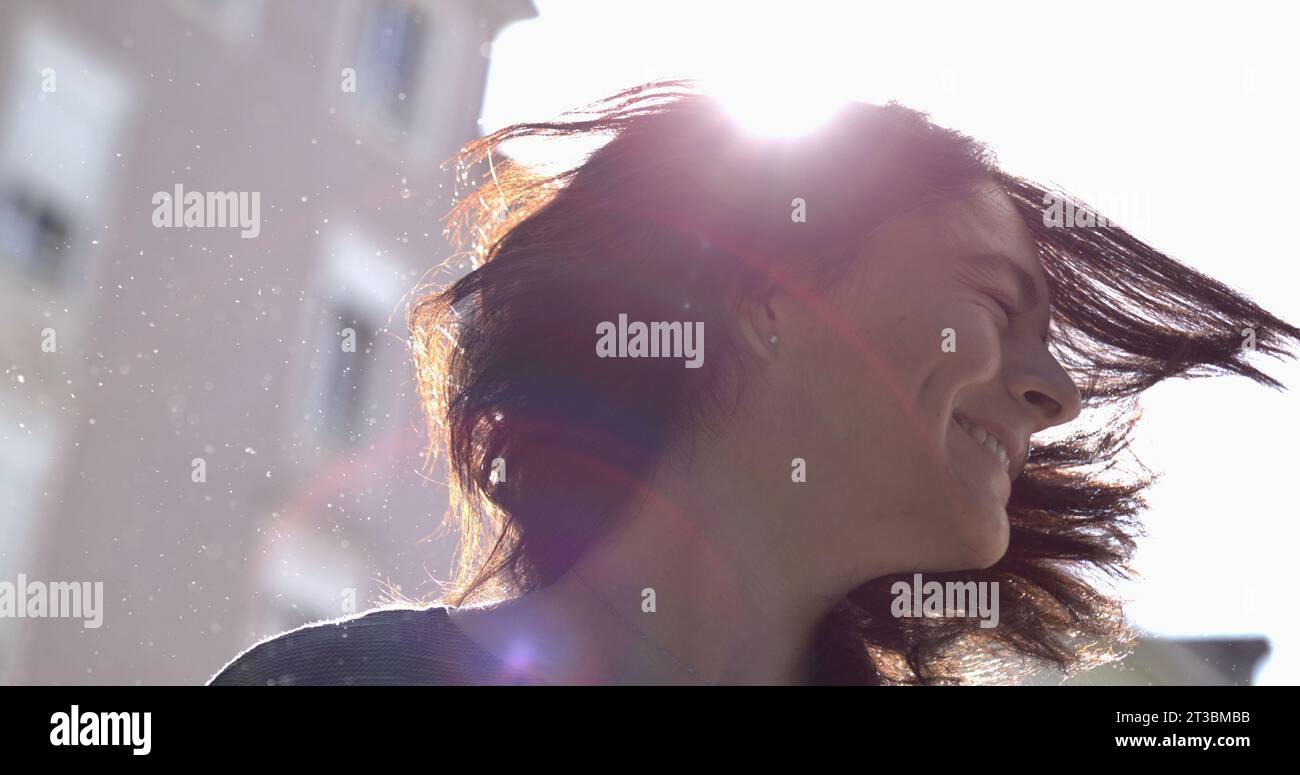 Carefree woman shaking hair in super slow-motion outside in the ...