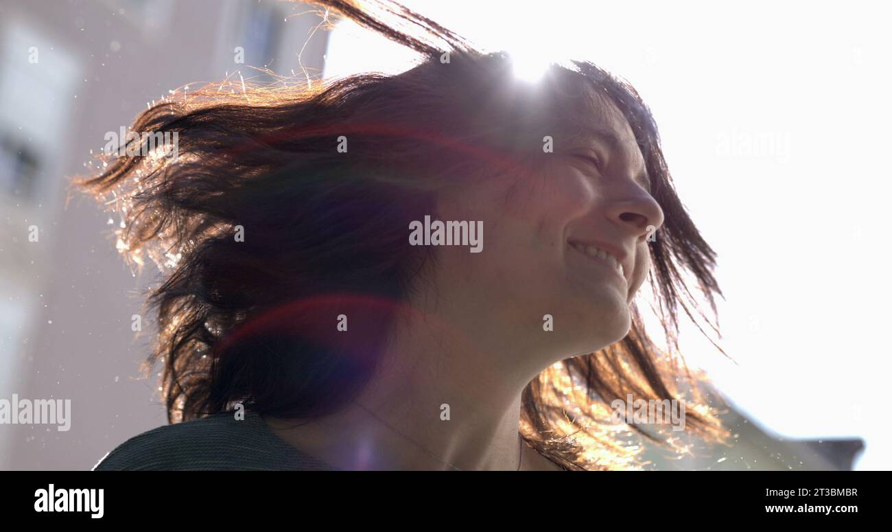 Carefree woman shaking hair in super slow-motion outside in the ...
