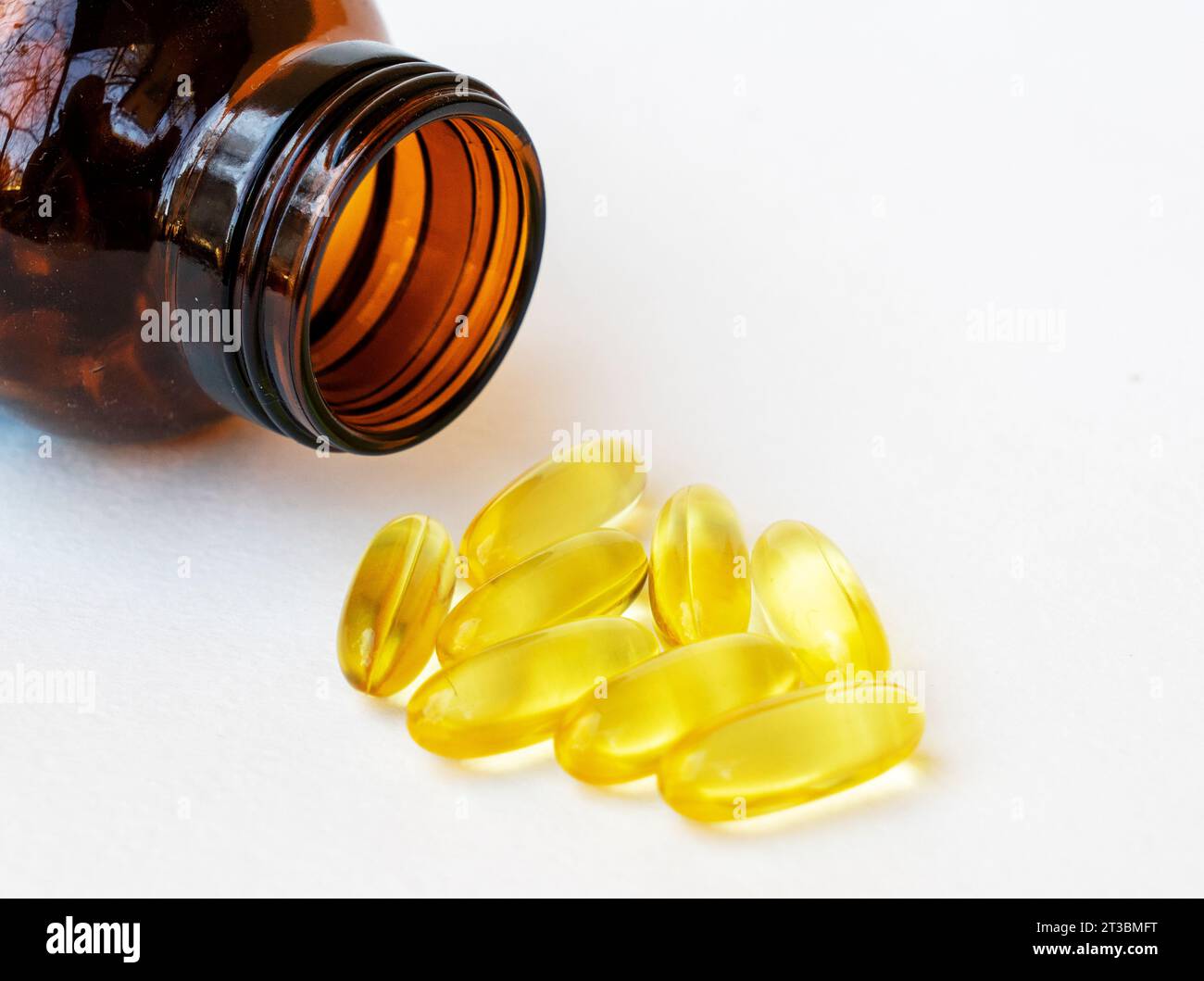 Pile of yellow fish oil capsules and pill glass bottle, fish oil ...