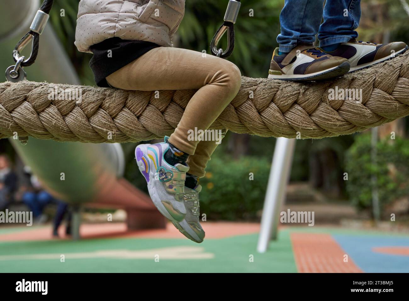 Unrecognizable boy and girl swinging from rope at the park Stock Photo ...