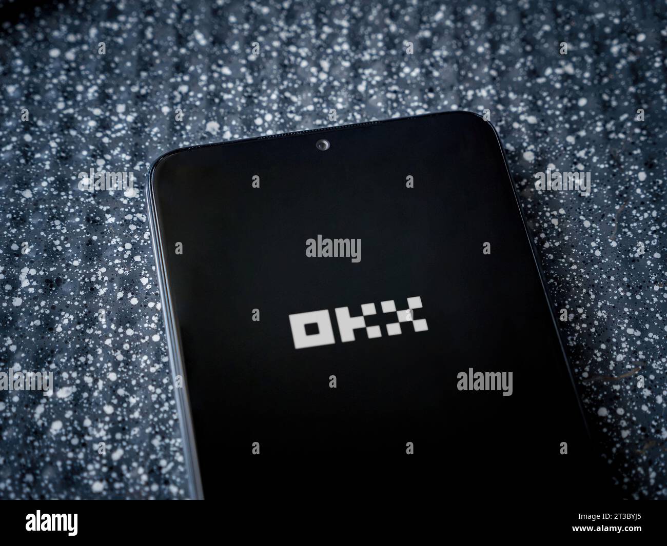 Lod, Israel - July 16,2023: OKX app launch screen on smartphone on metallic background. Close up ...