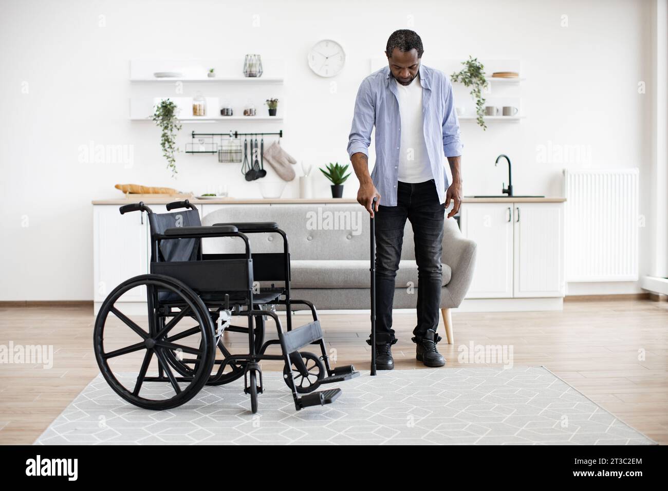 African man with disability using walking stick when raising from ...