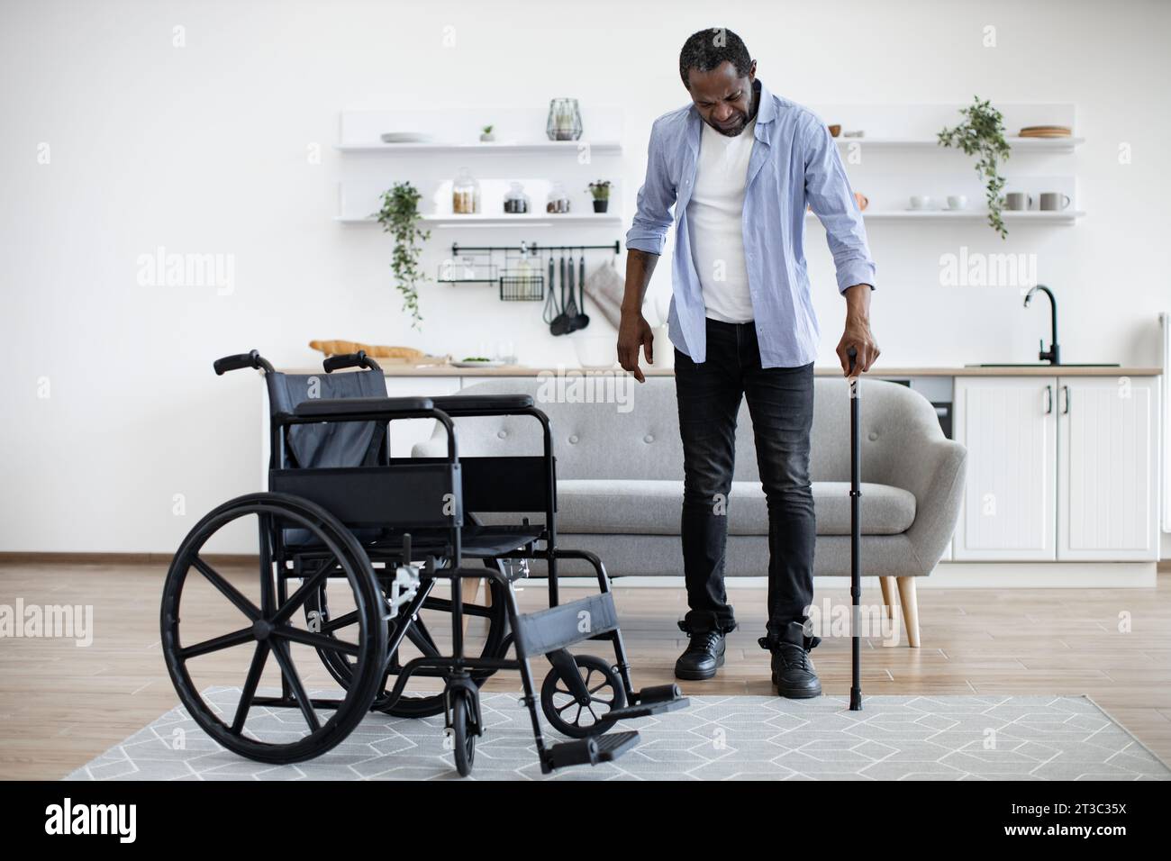 African man with disability using walking stick when raising from ...