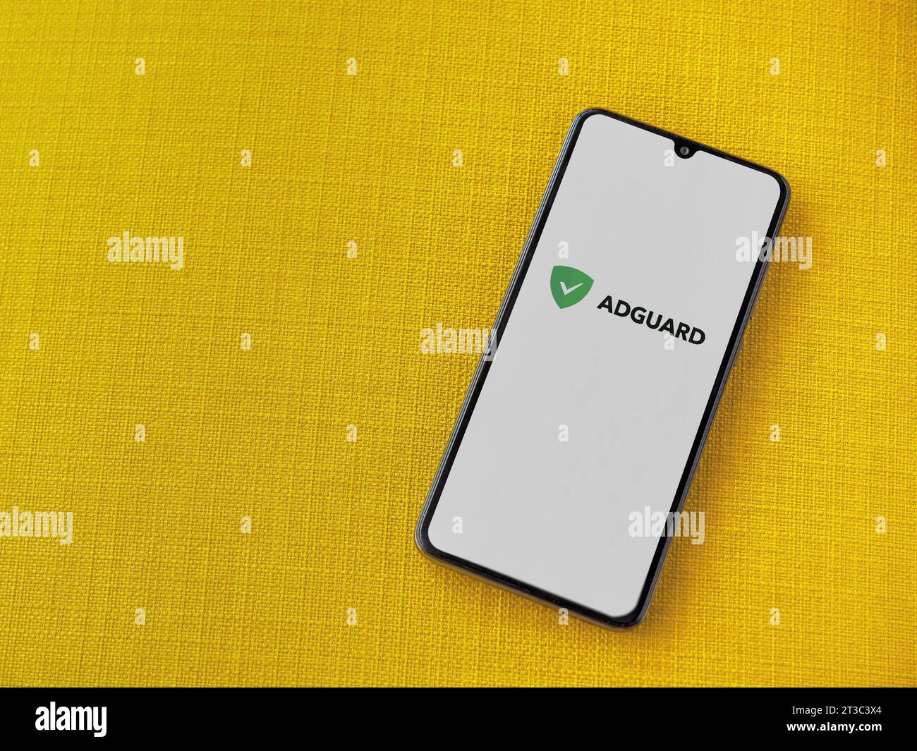 Lod, Israel - July 16,2023: AdGuard app launch screen on smartphone on yellow fabric background ...