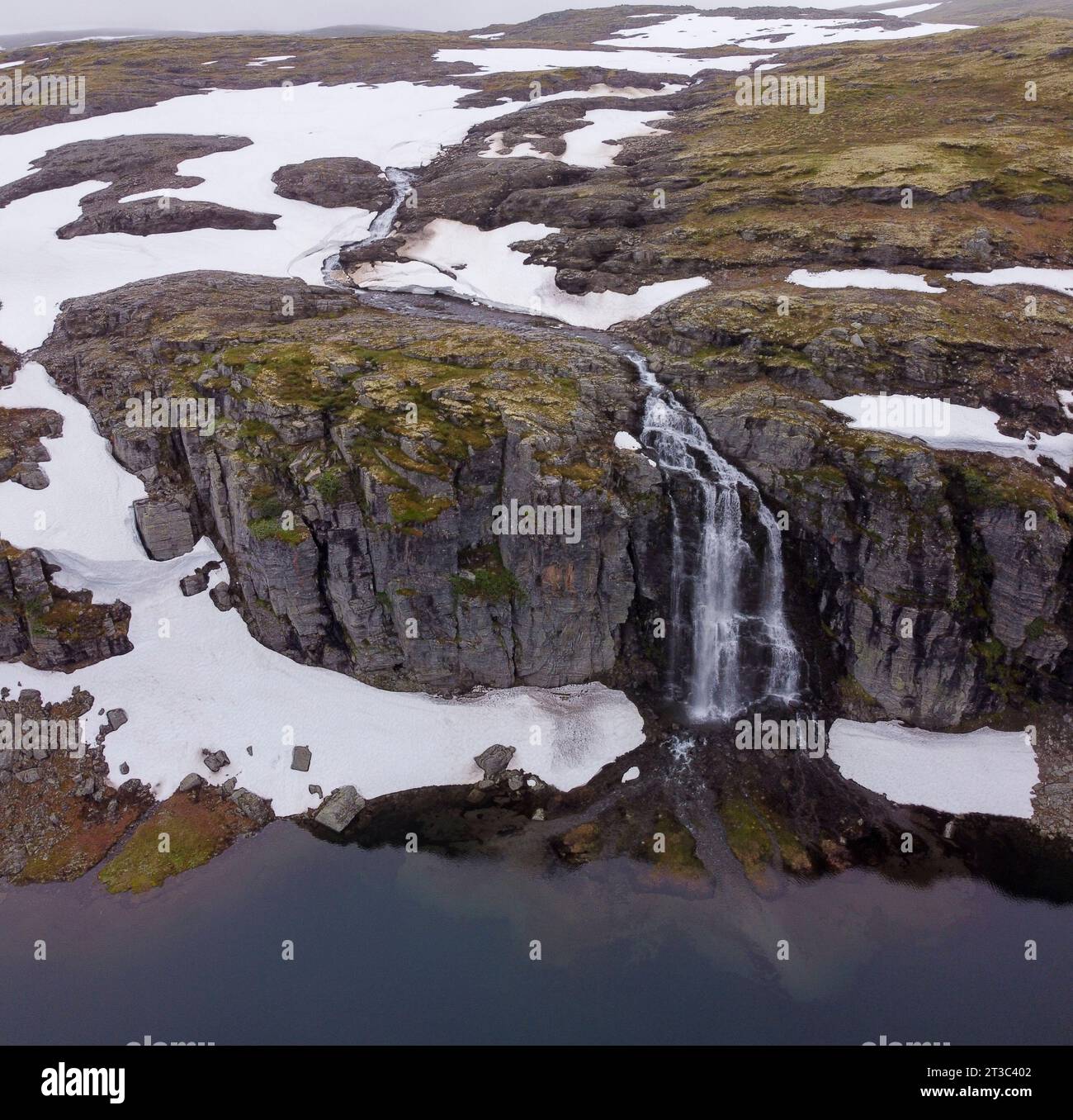 Aerial photo of a waterfall and a mountain lake near the old road over ...