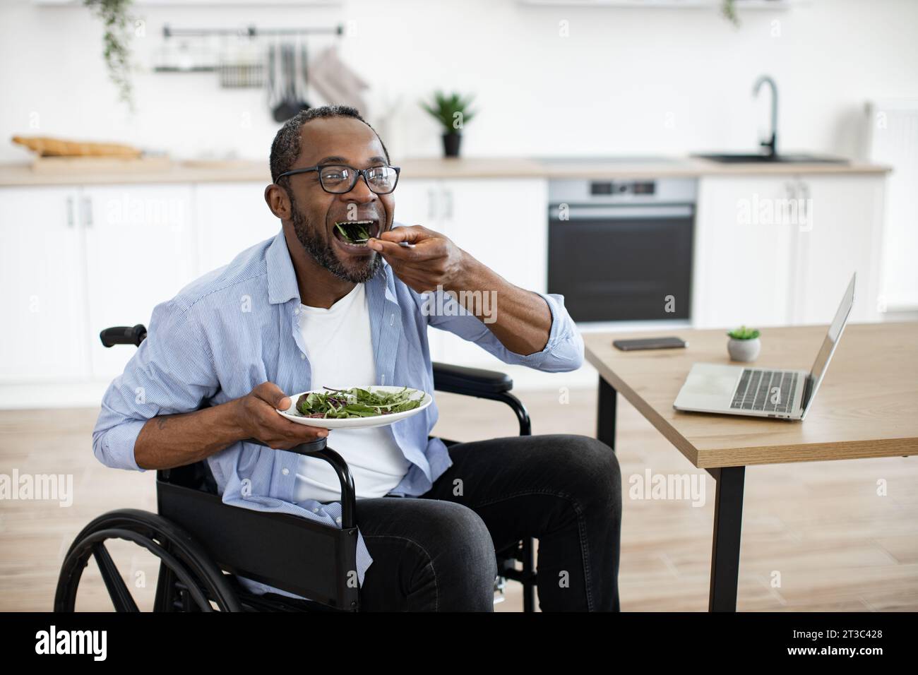 Manager with disability enjoying food in home workplace Stock Photo - Alamy