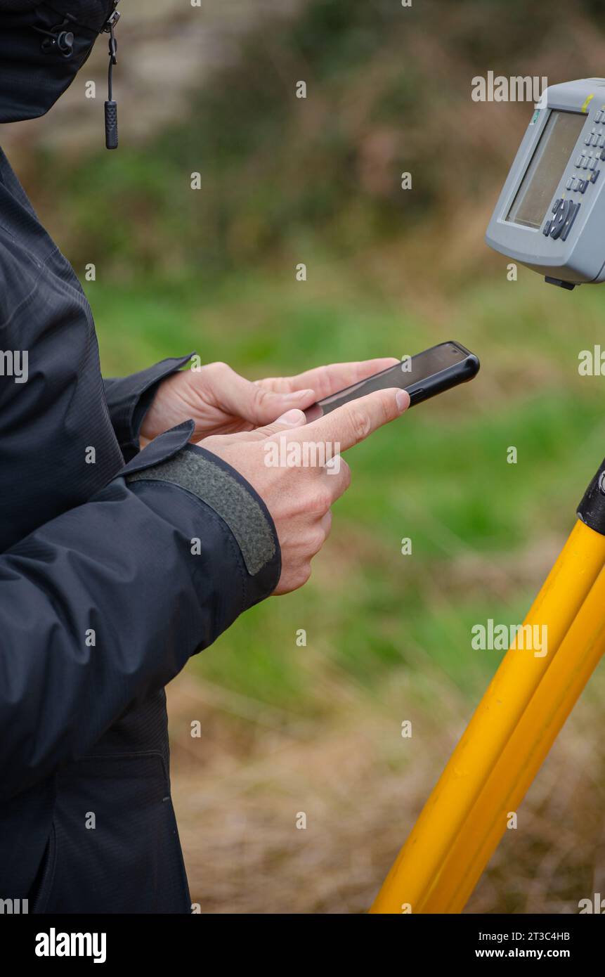 detail of a surveyor's hands configuring the total station with the ...