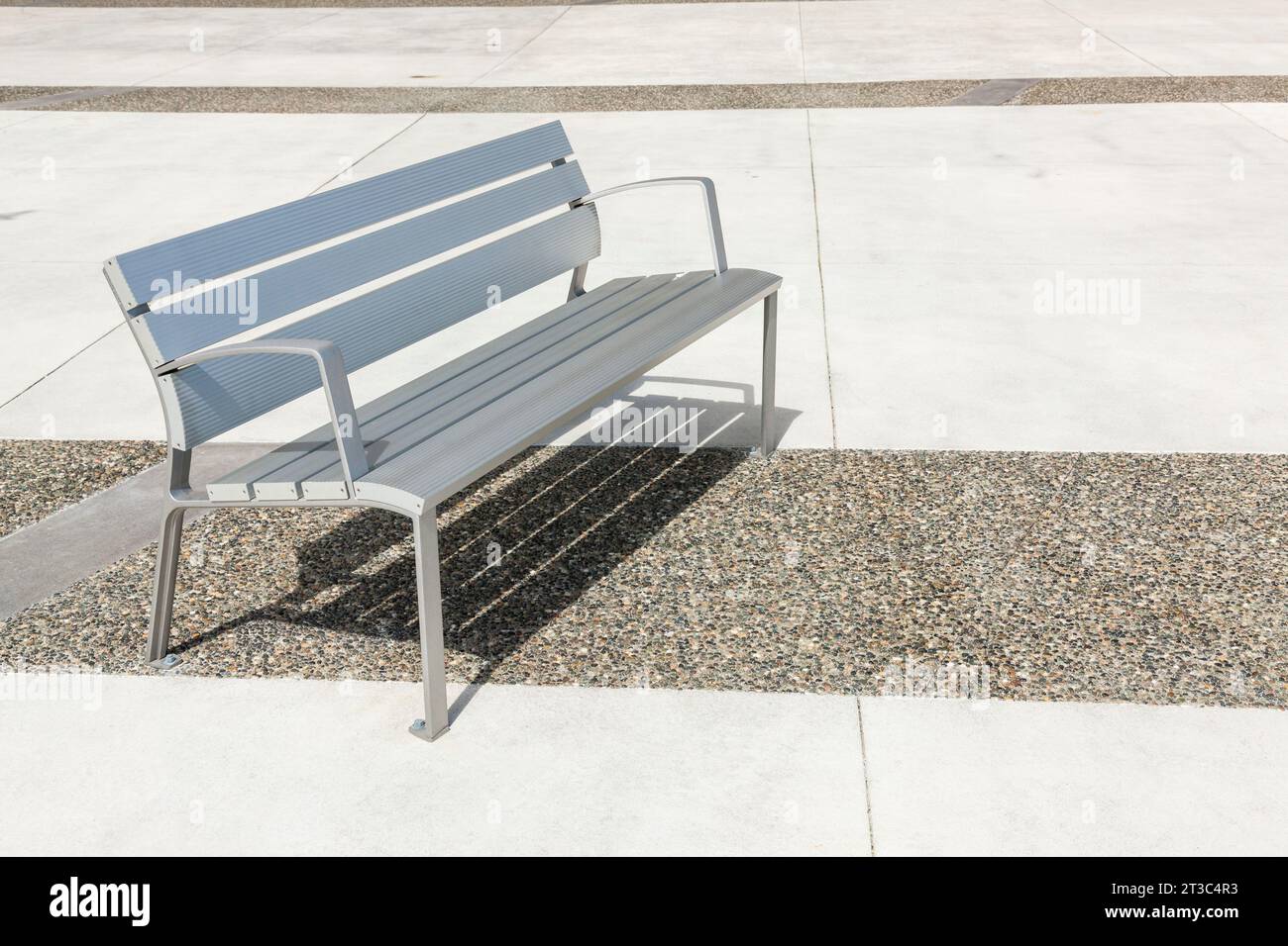 Metal bench on urban sidewalk Stock Photo - Alamy