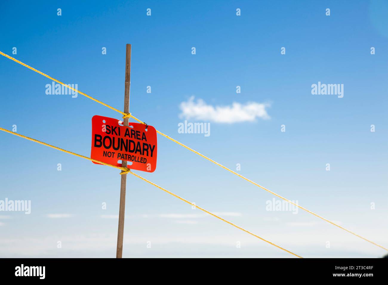 Ski area boundary sign against a blue sky and a puffy cloud Stock Photo ...
