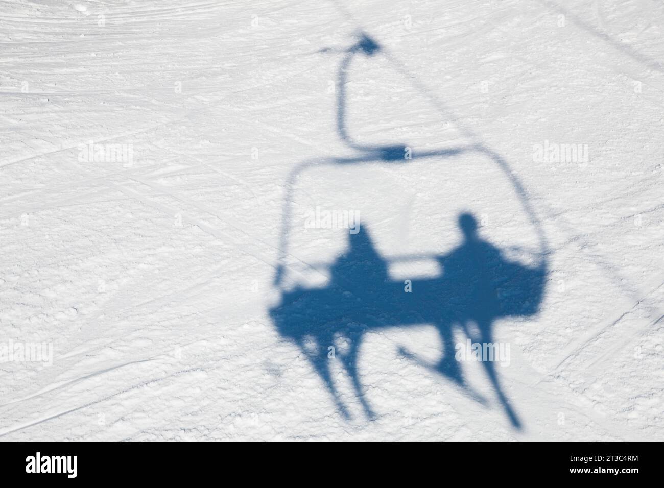 Shadow of chair lift with two people on snow-covered ski slope Stock ...