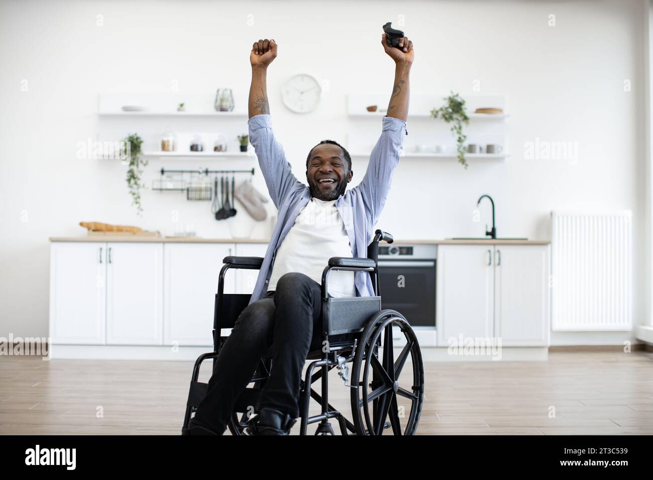 African person in wheelchair raising hands with joystick Stock Photo ...