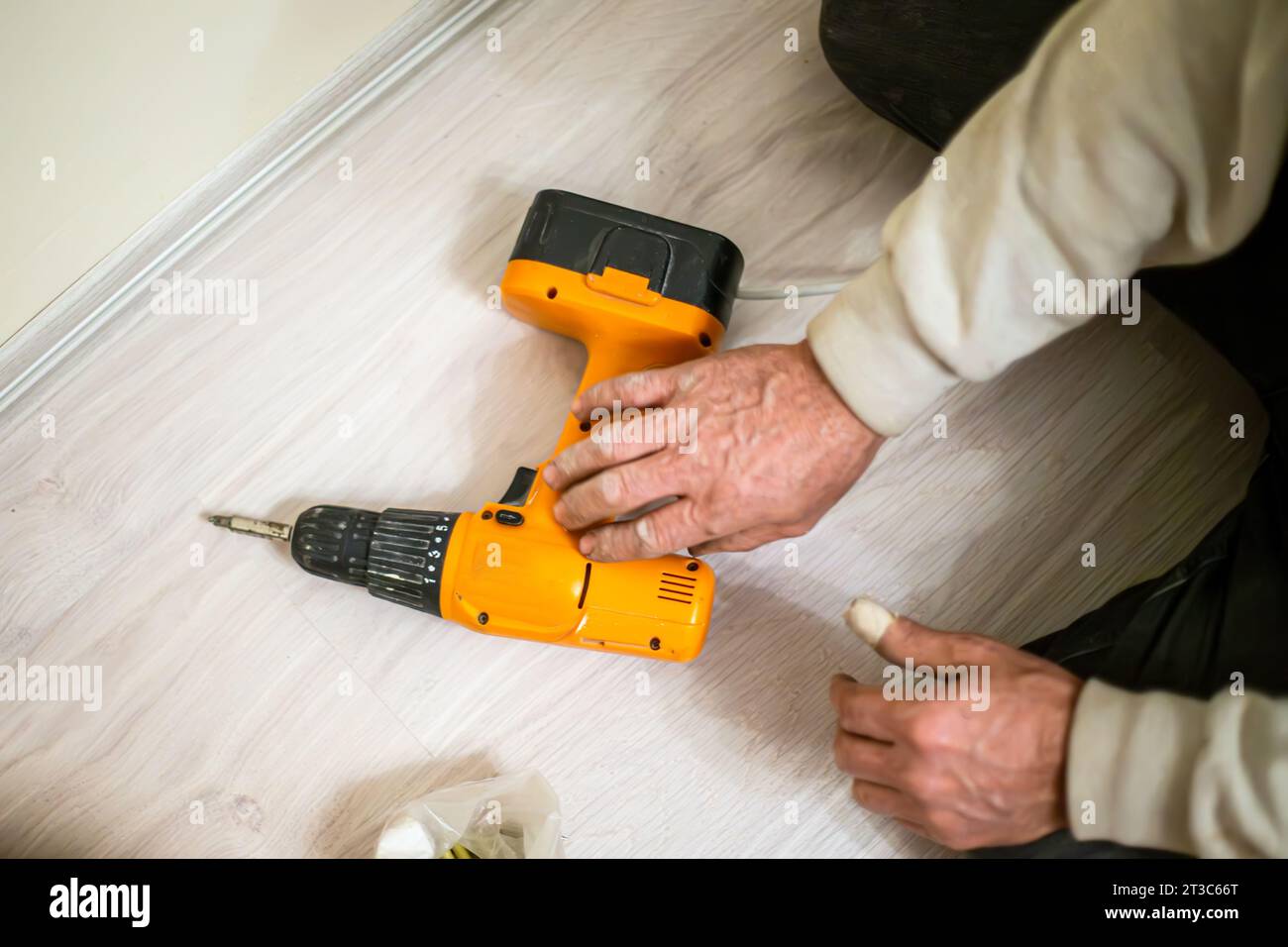 Hands of an elderly man with an injured finger while renovating a house ...