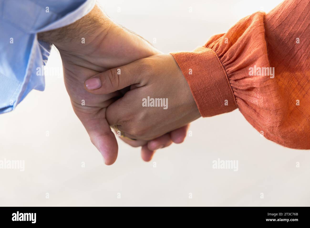 Couple's hands intertwined in love Stock Photo - Alamy