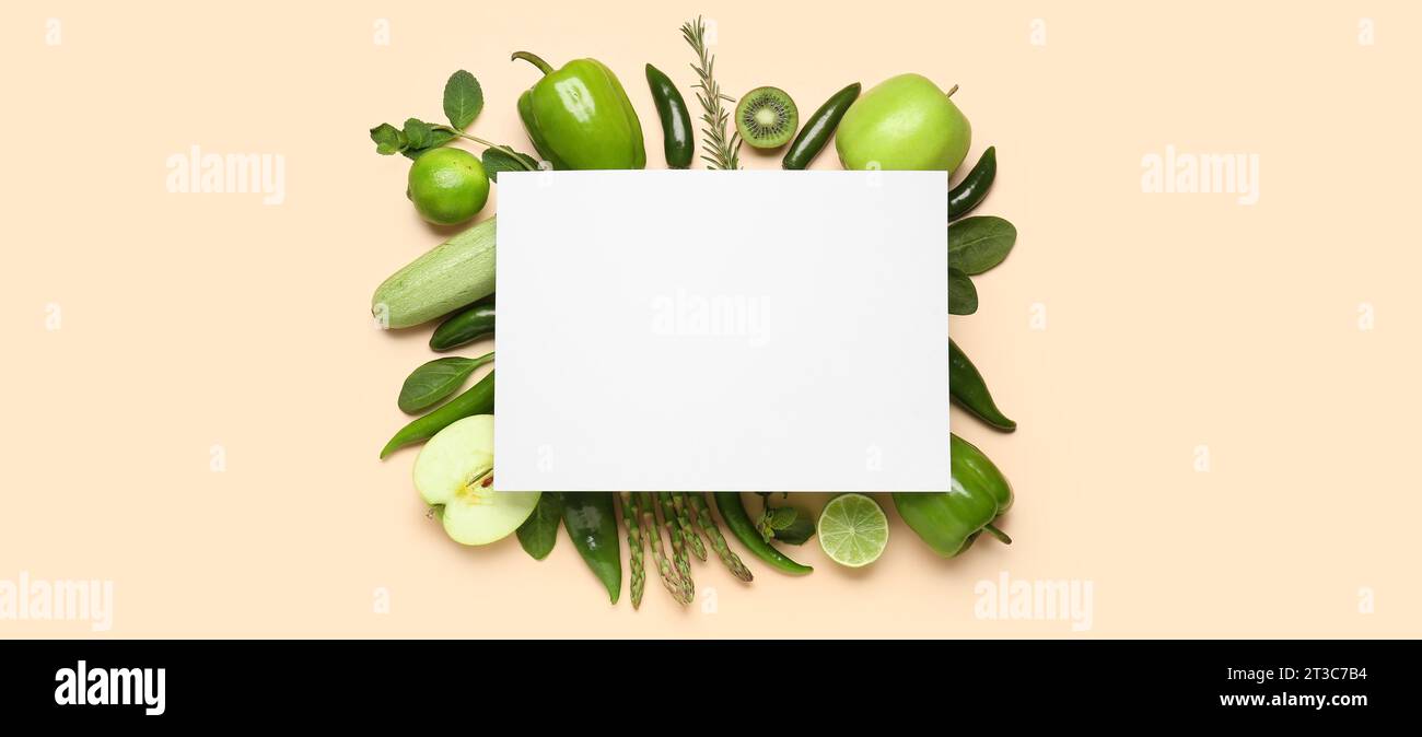 Different green vegetables, fruits and blank paper sheet on beige ...