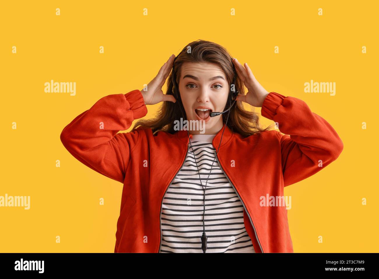 Shocked female technical support agent on yellow background Stock Photo ...