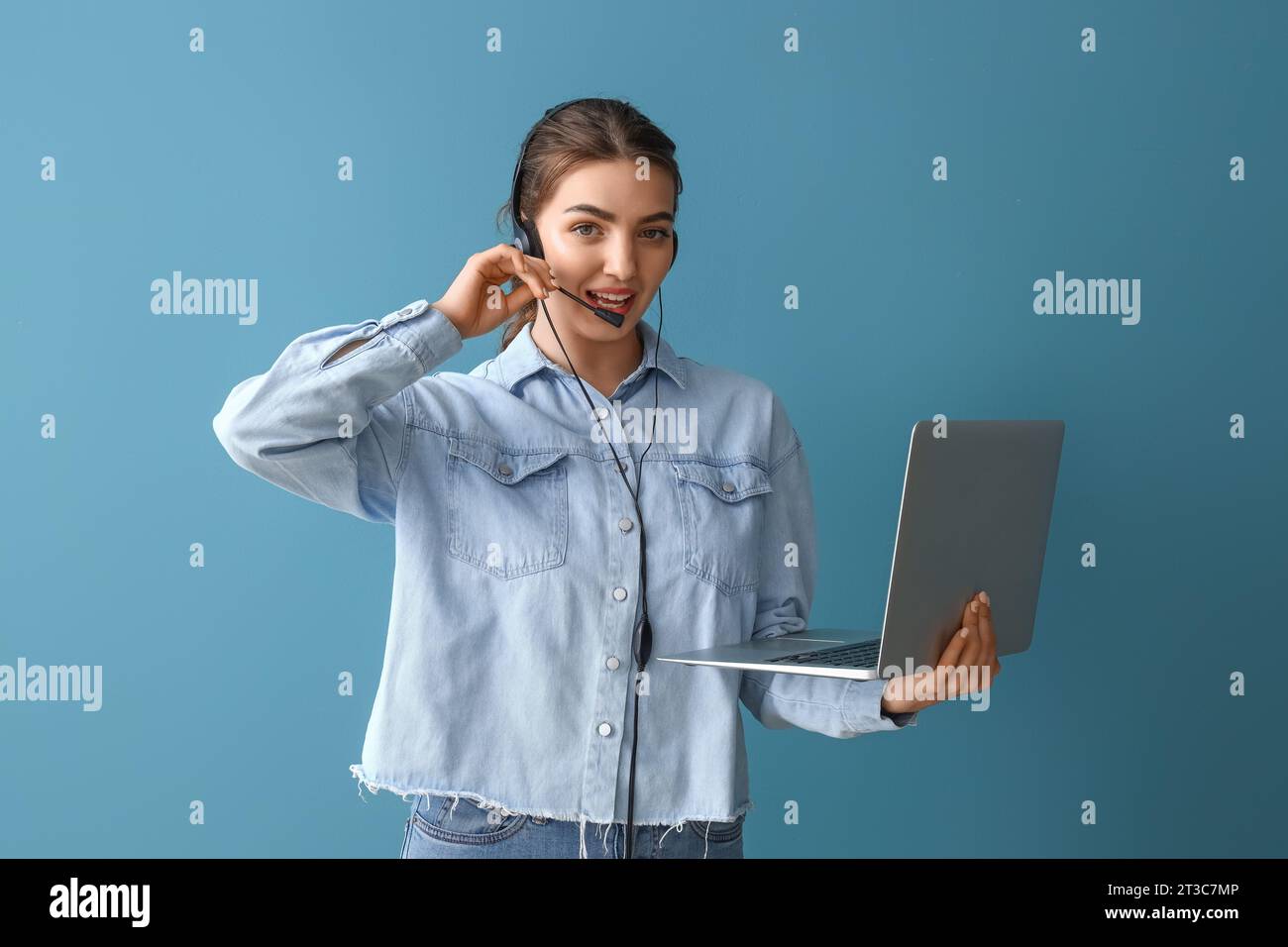 Female technical support agent with laptop on blue background Stock ...