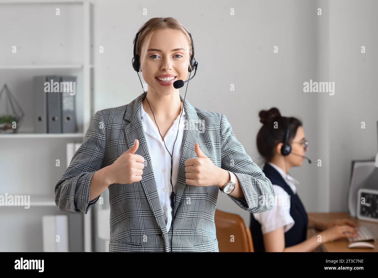 Female technical support agent showing thumb-up in office Stock Photo ...