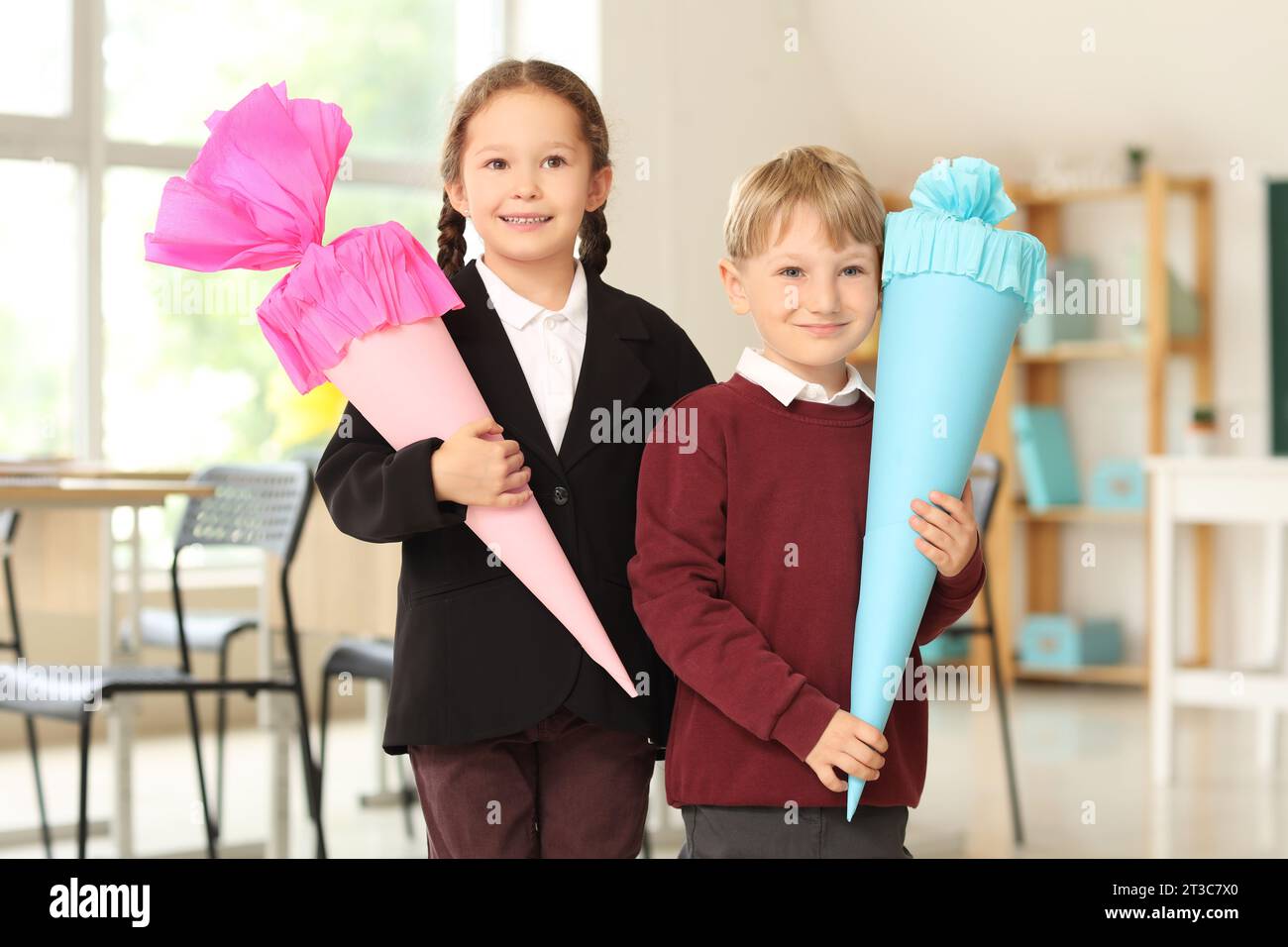 Happy classmates with colorful school cones in classroom Stock Photo ...