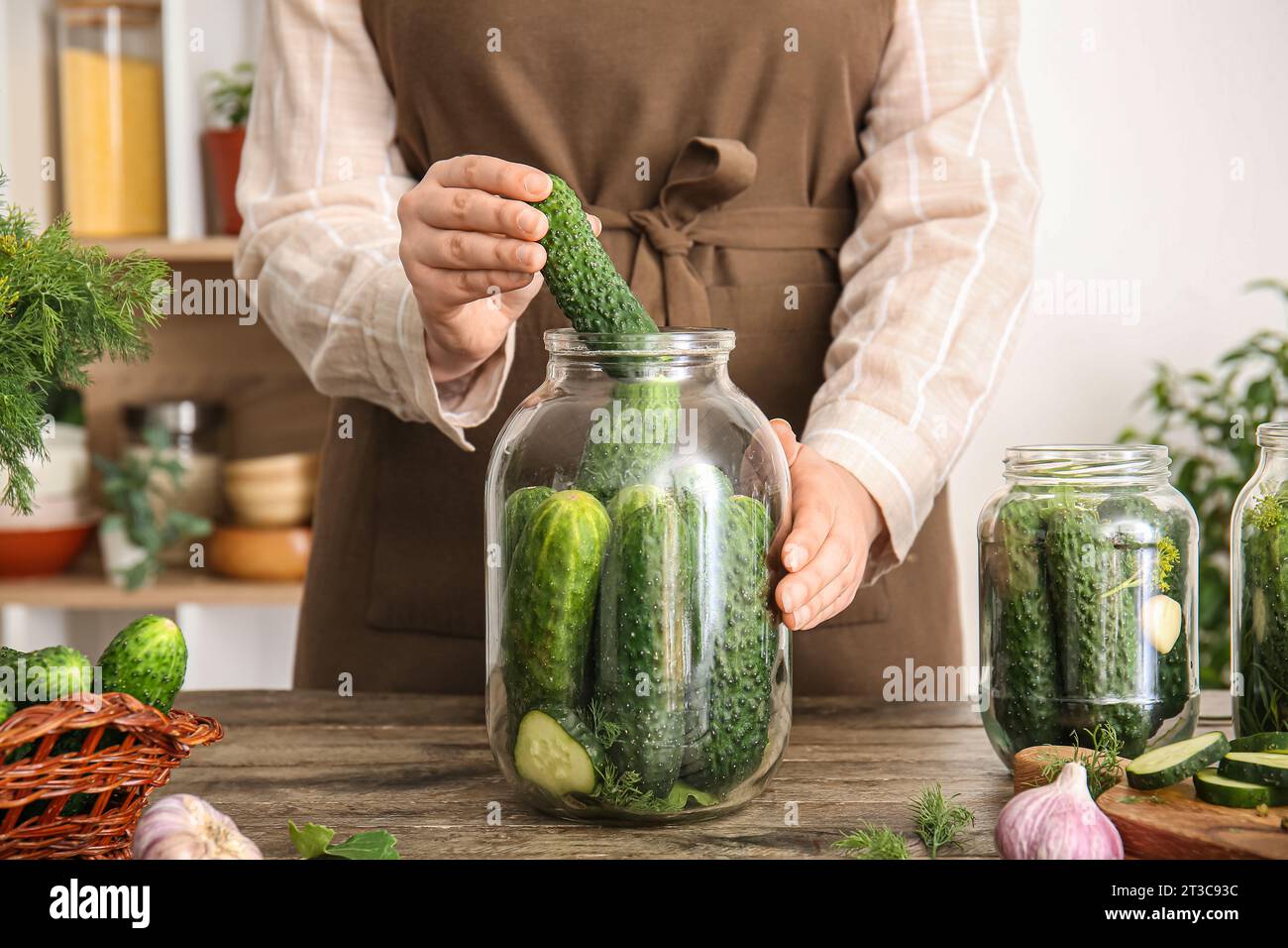 Woman preparing fresh cucumbers for canning at table in kitchen Stock ...