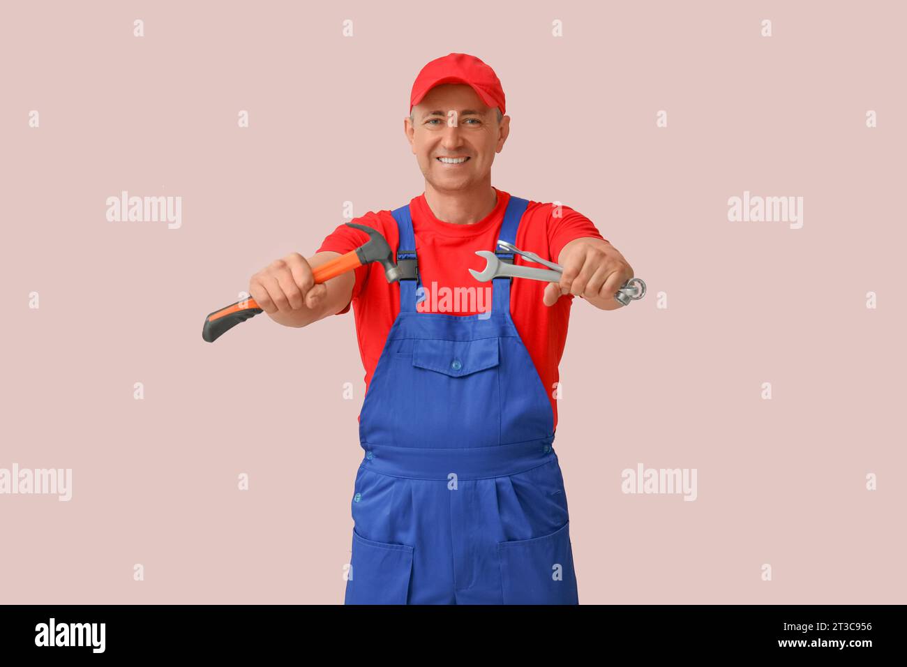 Portrait of male mechanic with tools on pink background Stock Photo - Alamy