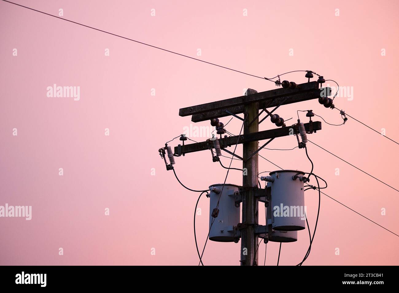 Utility pole with distribution transformers against pink sky Stock Photo - Alamy
