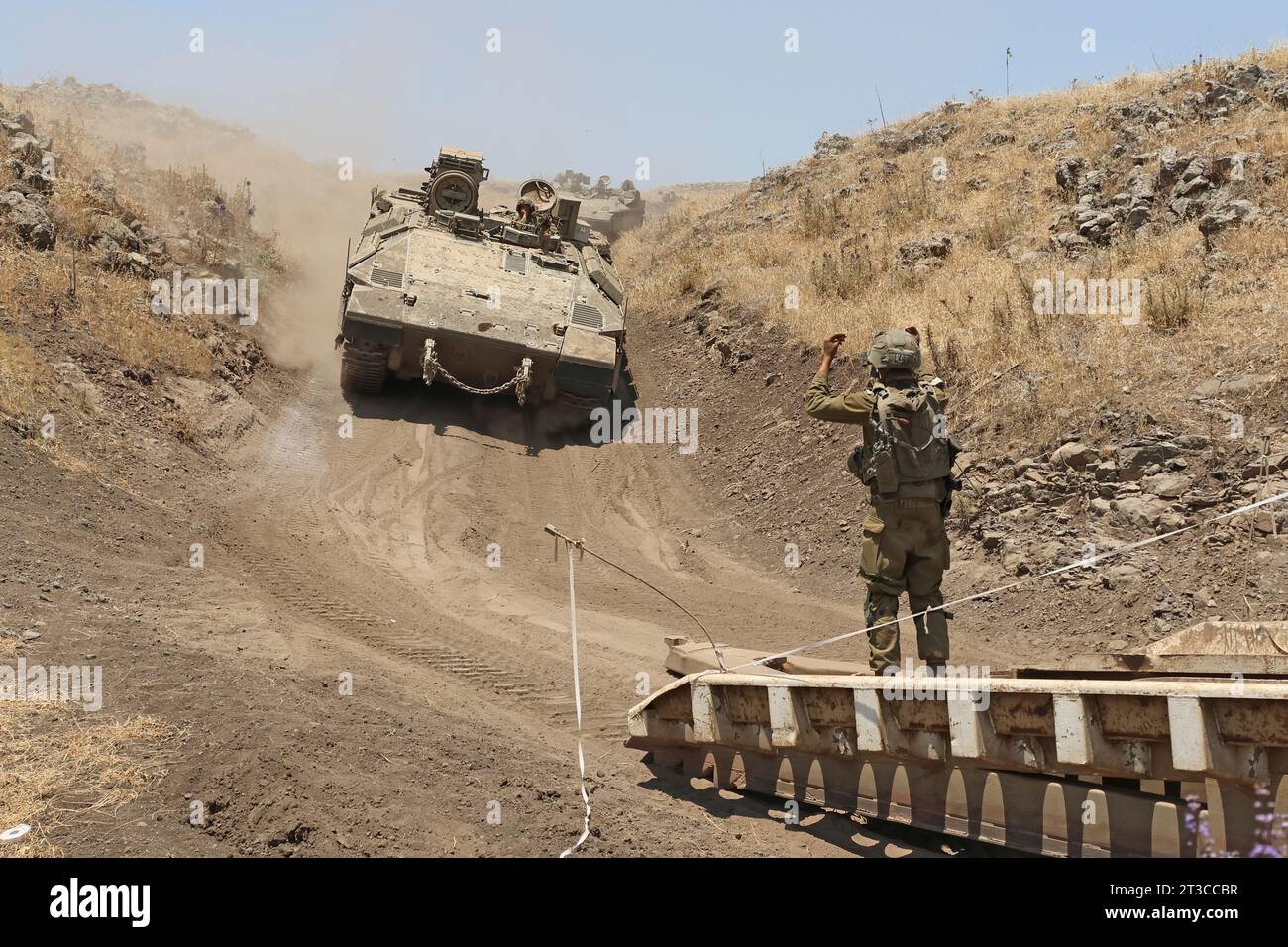 Namer APC of the Israel Defense Forces is guided onto a temporary ...