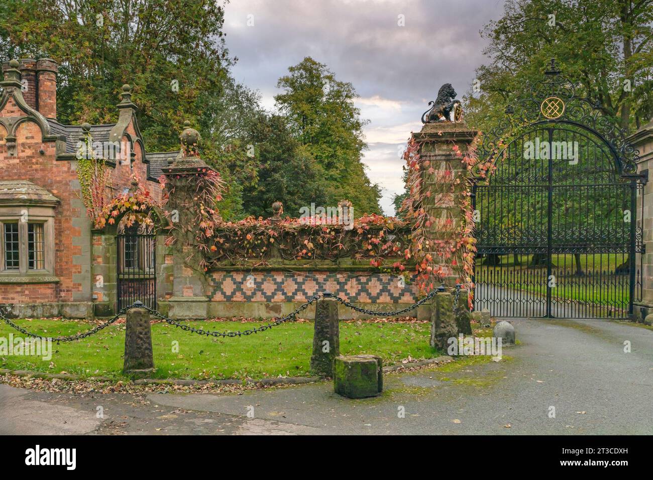 Gateway with wrought iron gate and Virginia creeper plant changing ...