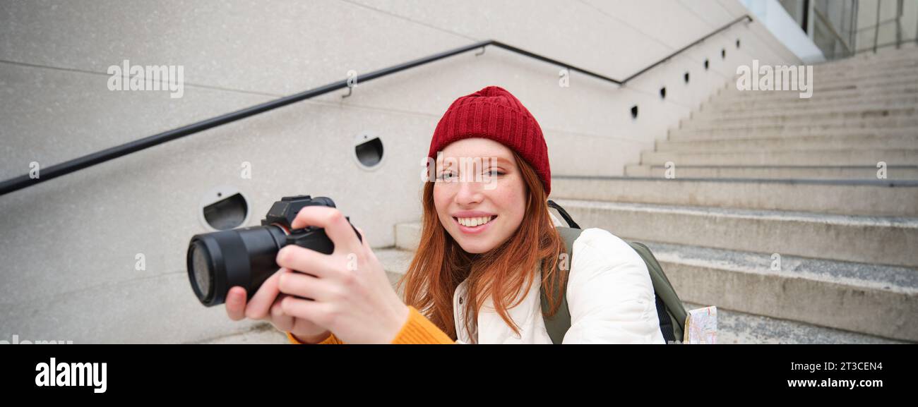 Portrait of female photographer walking around city with professional ...