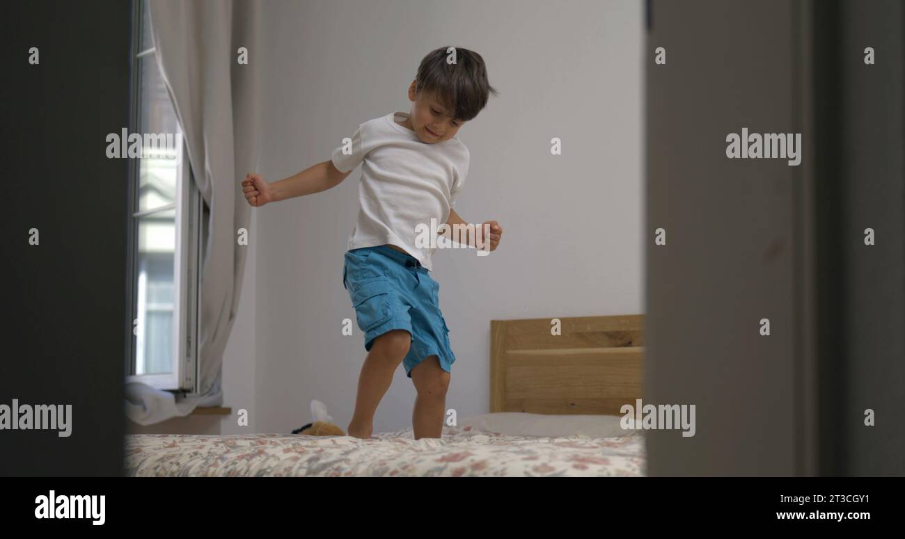 Excited happy child jumping up and down in bed in slow-motion. 1000 fps ...