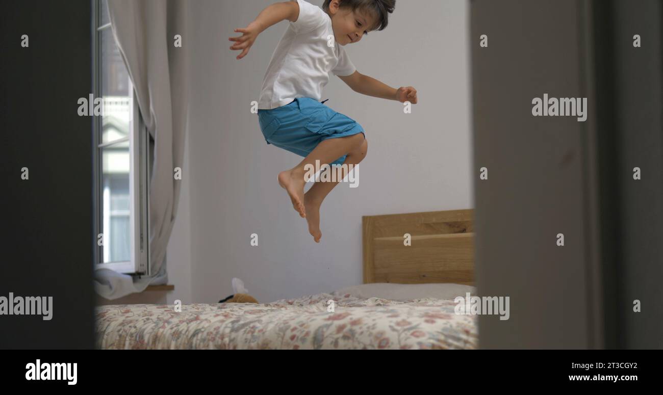 Excited happy child jumping up and down in bed in slow-motion. 1000 fps ...
