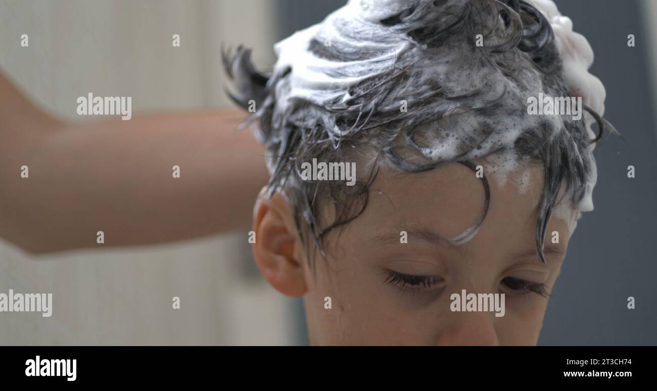 Speed ramp of young boy bath time, parent washing and shampooing child ...