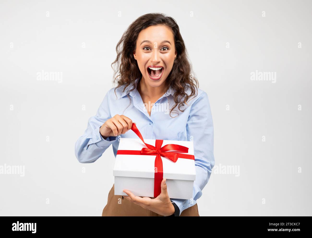 Glad millennial european woman in formal wear with open mouth open box ...
