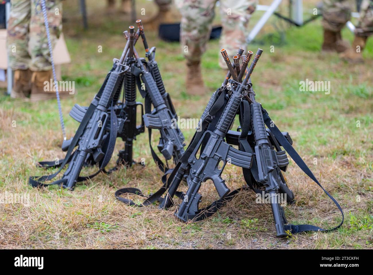 Modern black training military rifles stacked, leaning against each ...