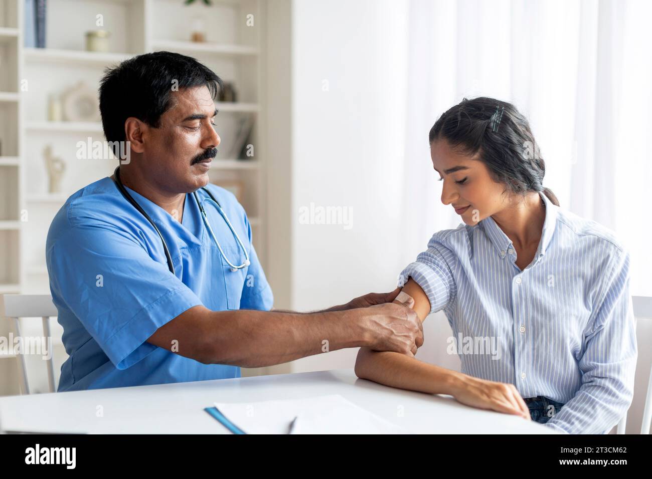 Antiviral Vaccination. Middle aged medical worker sticking plaster ...