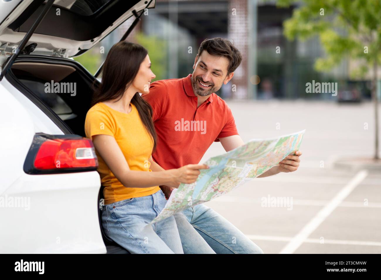 Happy millennial couple having car trip together, reading map Stock ...