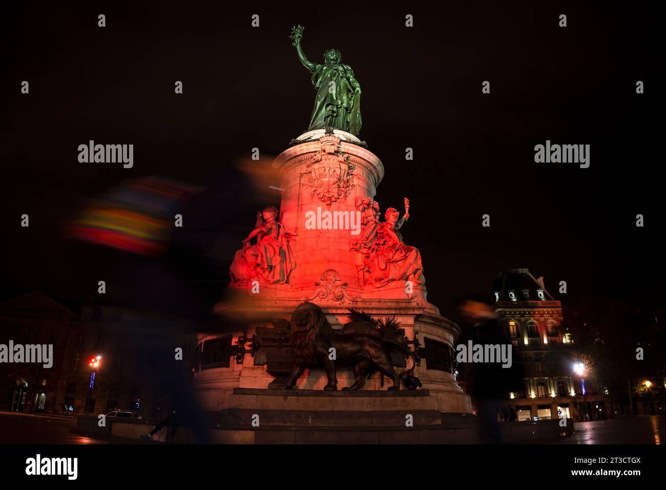 People walk past the lighted Monument a la Republique in Paris, France ...