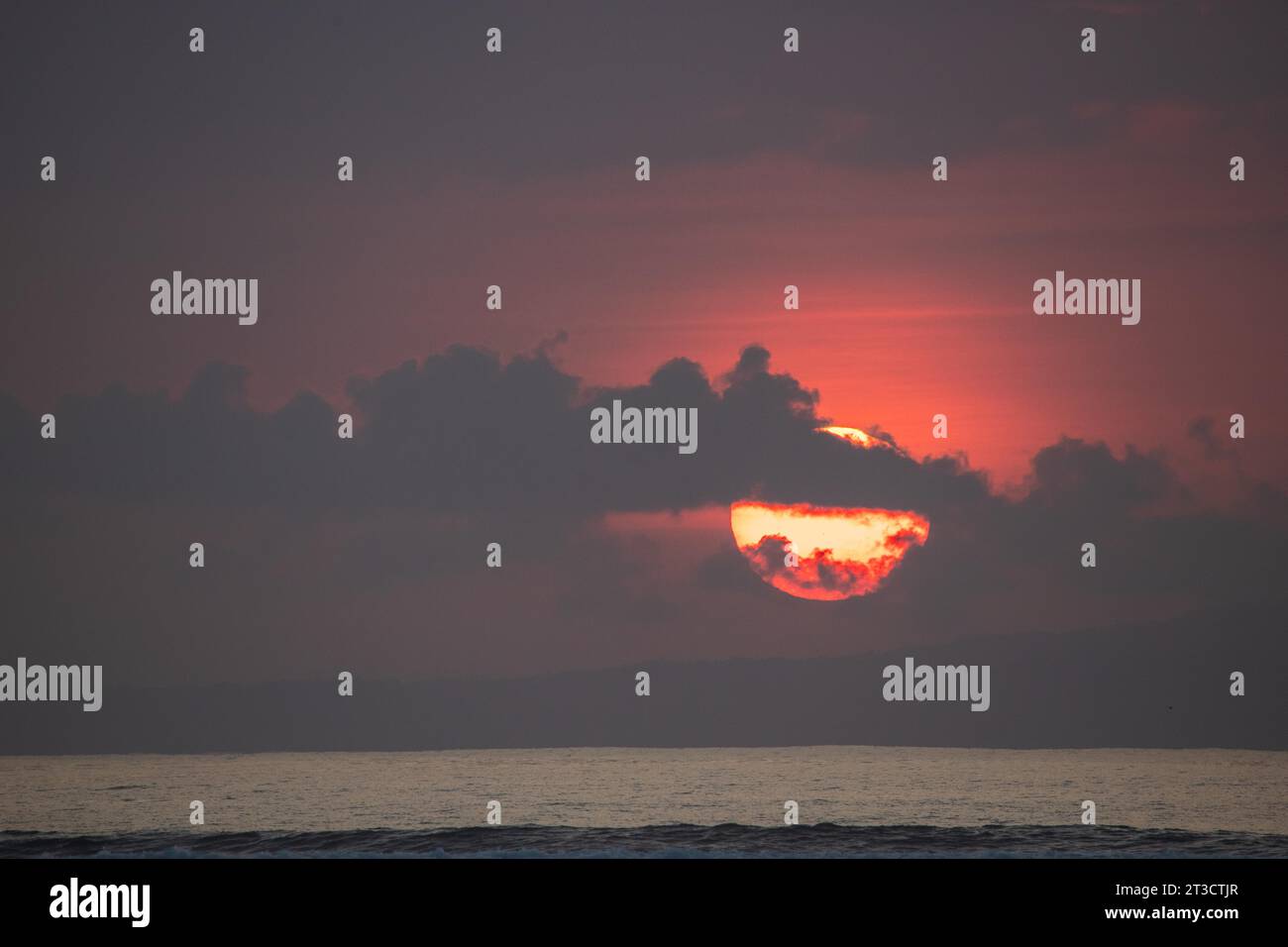 Sunrise on a sandy beach. Landscape shot with red circular sun on the ...